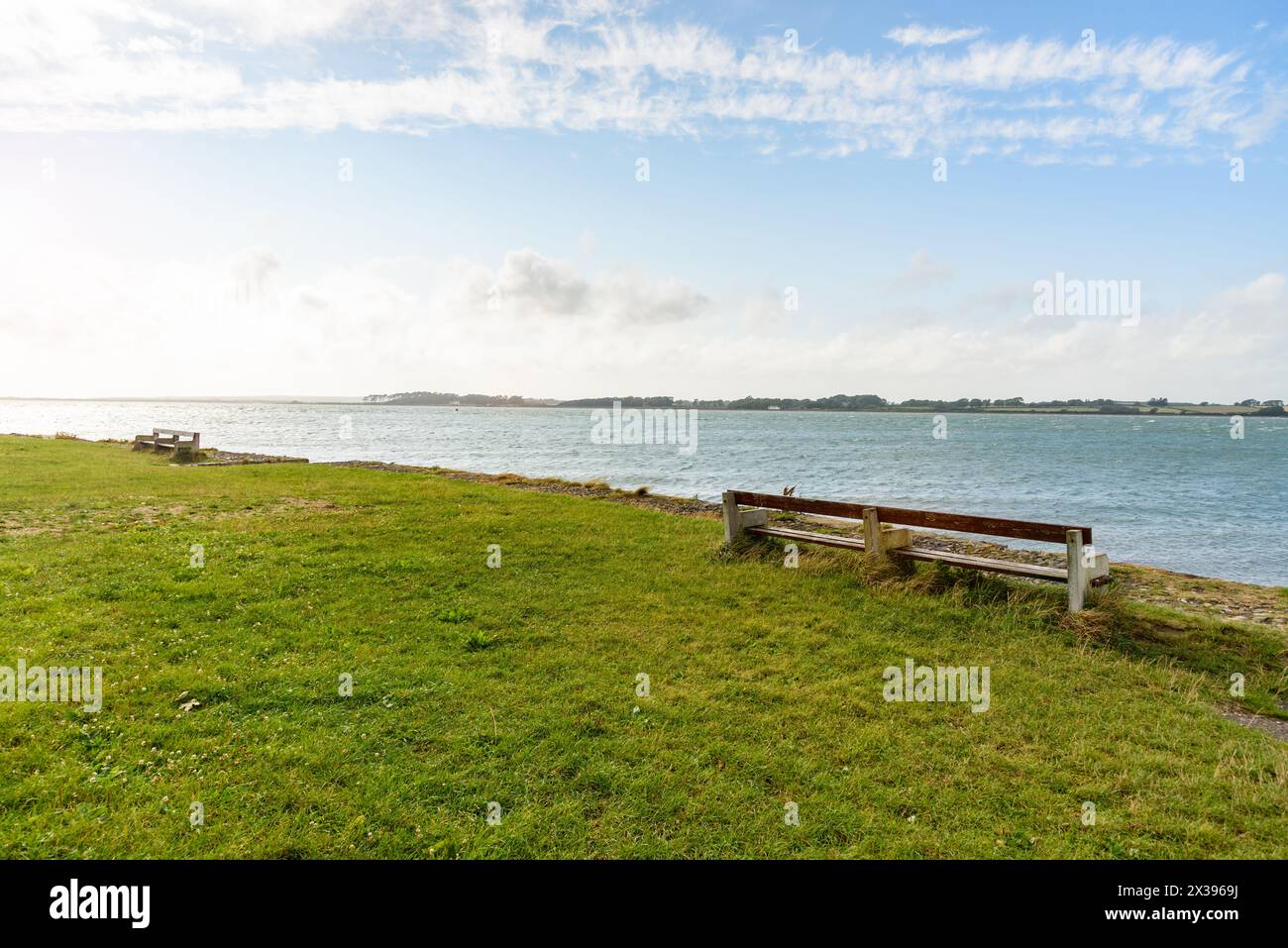 Empty woodend benches facing the sea on a clear summer day Stock Photo ...