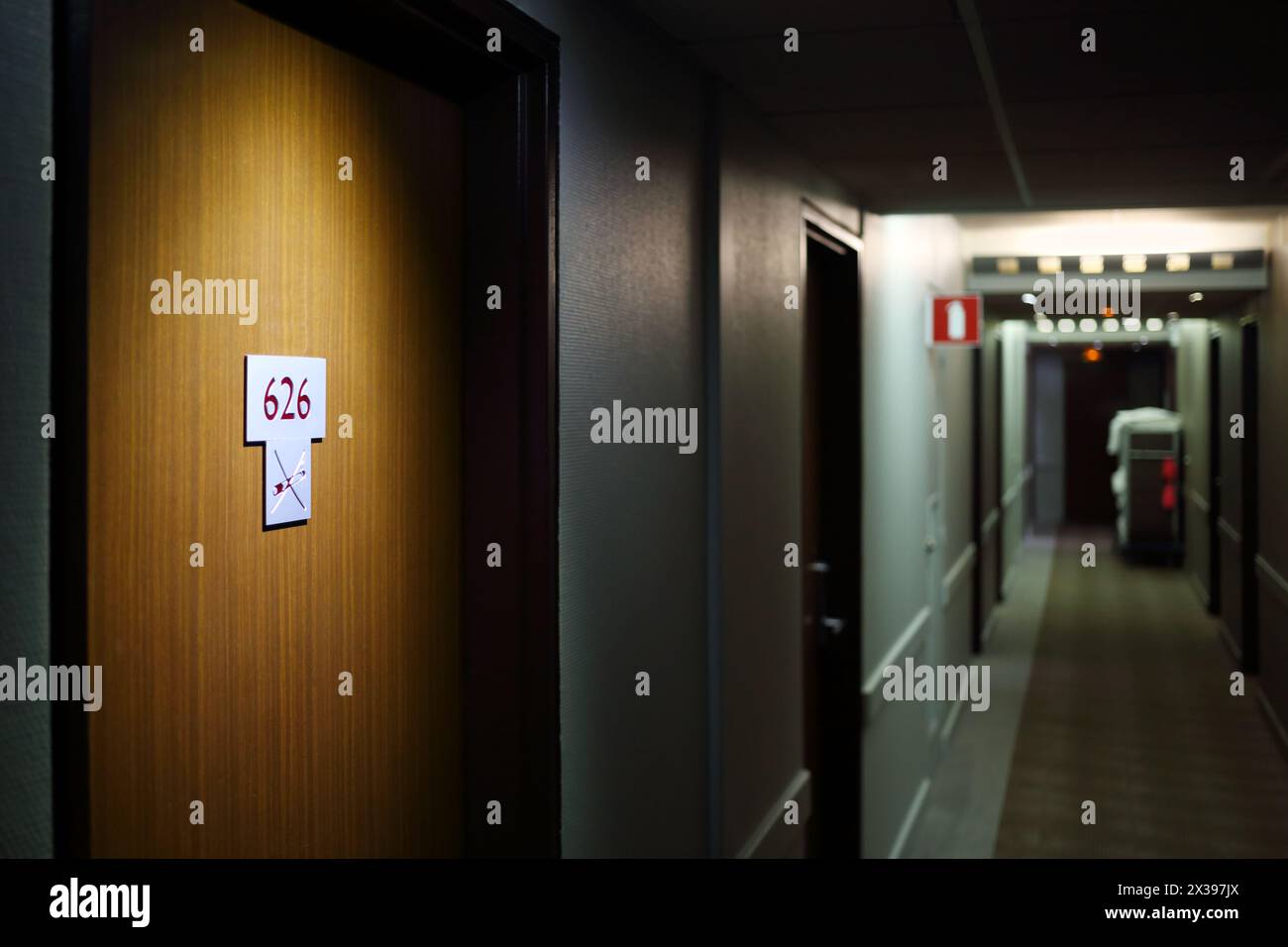 Dark hallway with doors of hotel rooms, illuminated 626 humber with ...