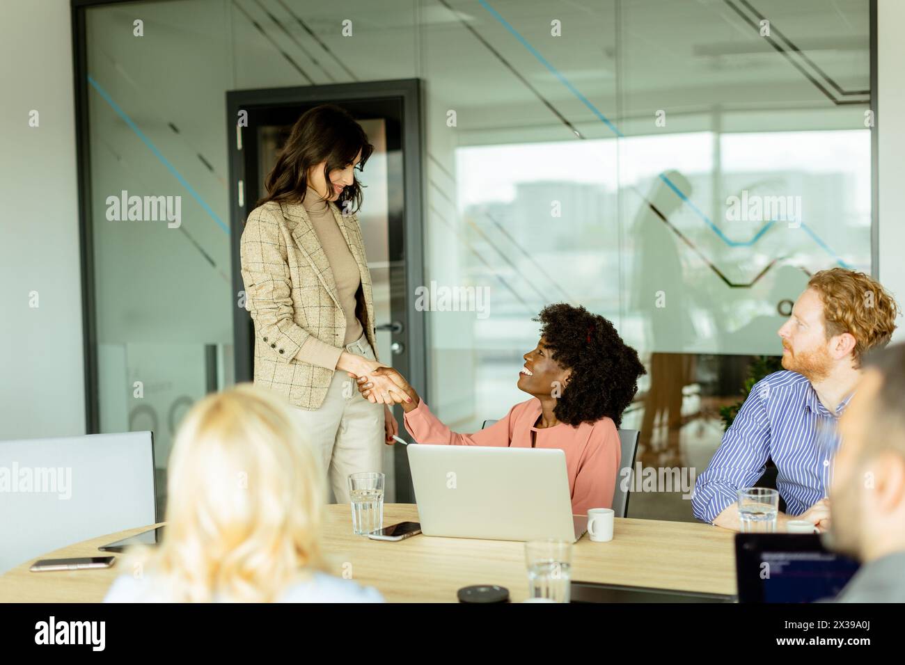 Two professionals warmly greeting each other with a handshake over a ...