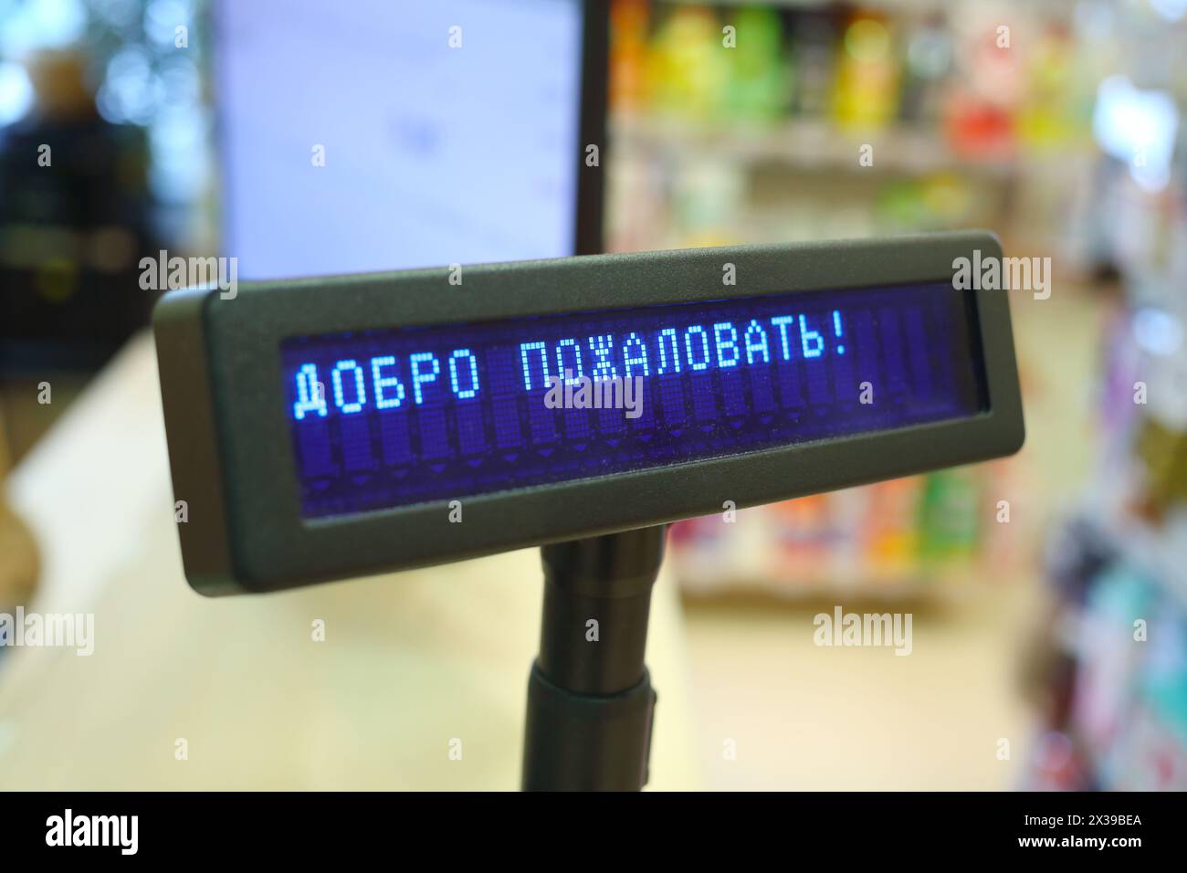Cash register in store, text - Welcome, goods for home are on shelves ...