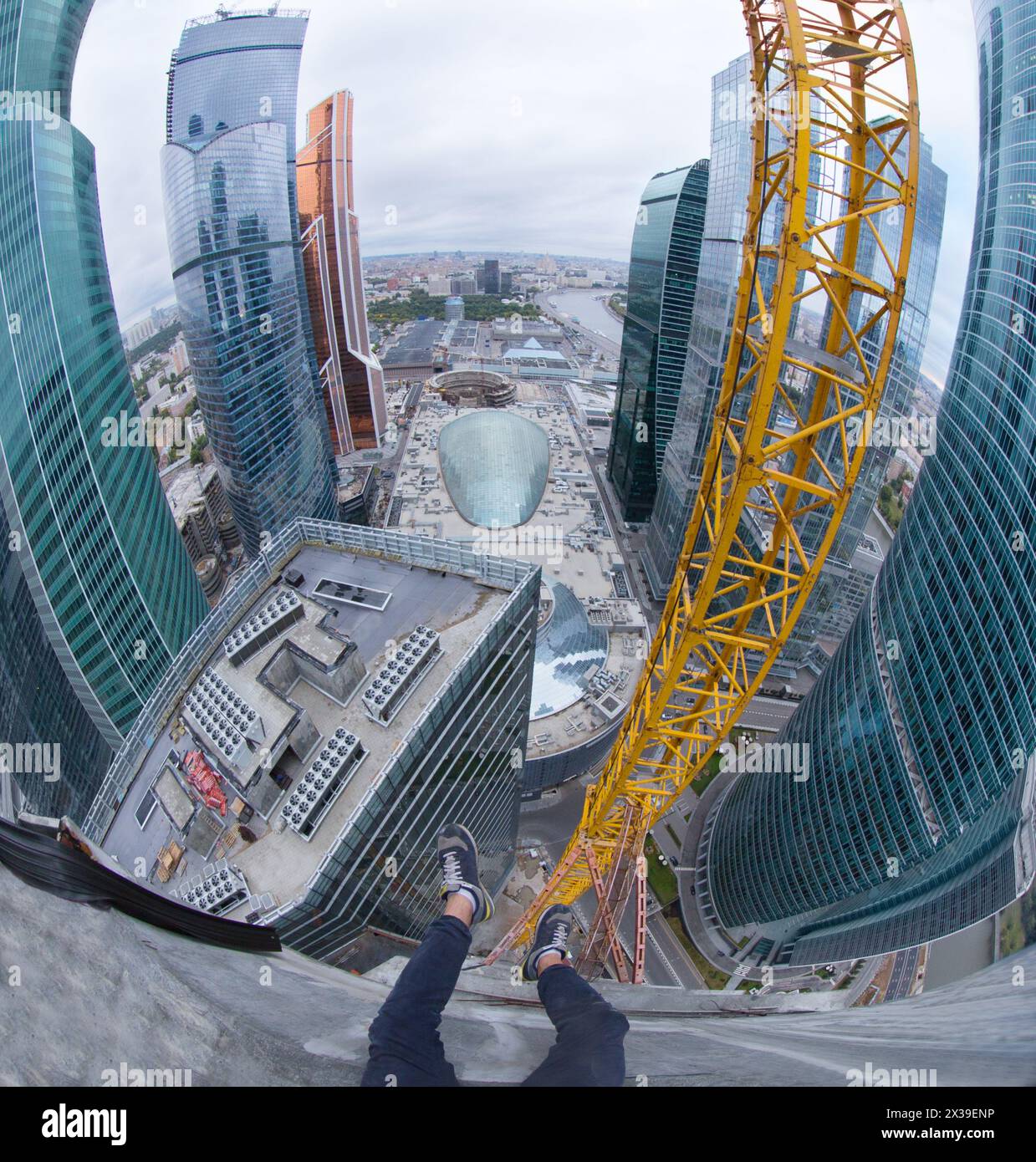 MOSCOW - AUG 30, 2015: Legs of man sitting on roof of building in ...