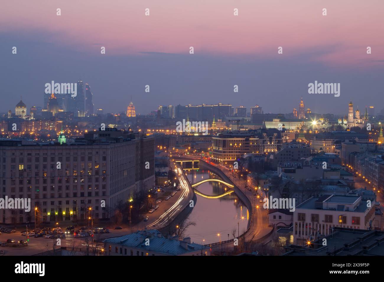 Drainage channel at Baltschug Island, sunset sky, bridge, roofs and ...