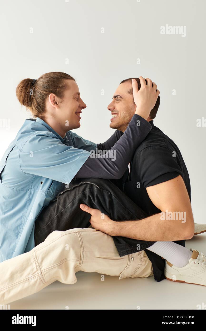 Two men sitting closely on the floor, sharing a moment of intimacy and ...