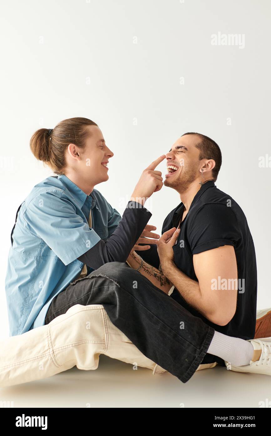 Two men sit together on the ground, displaying a sense of unity and ...
