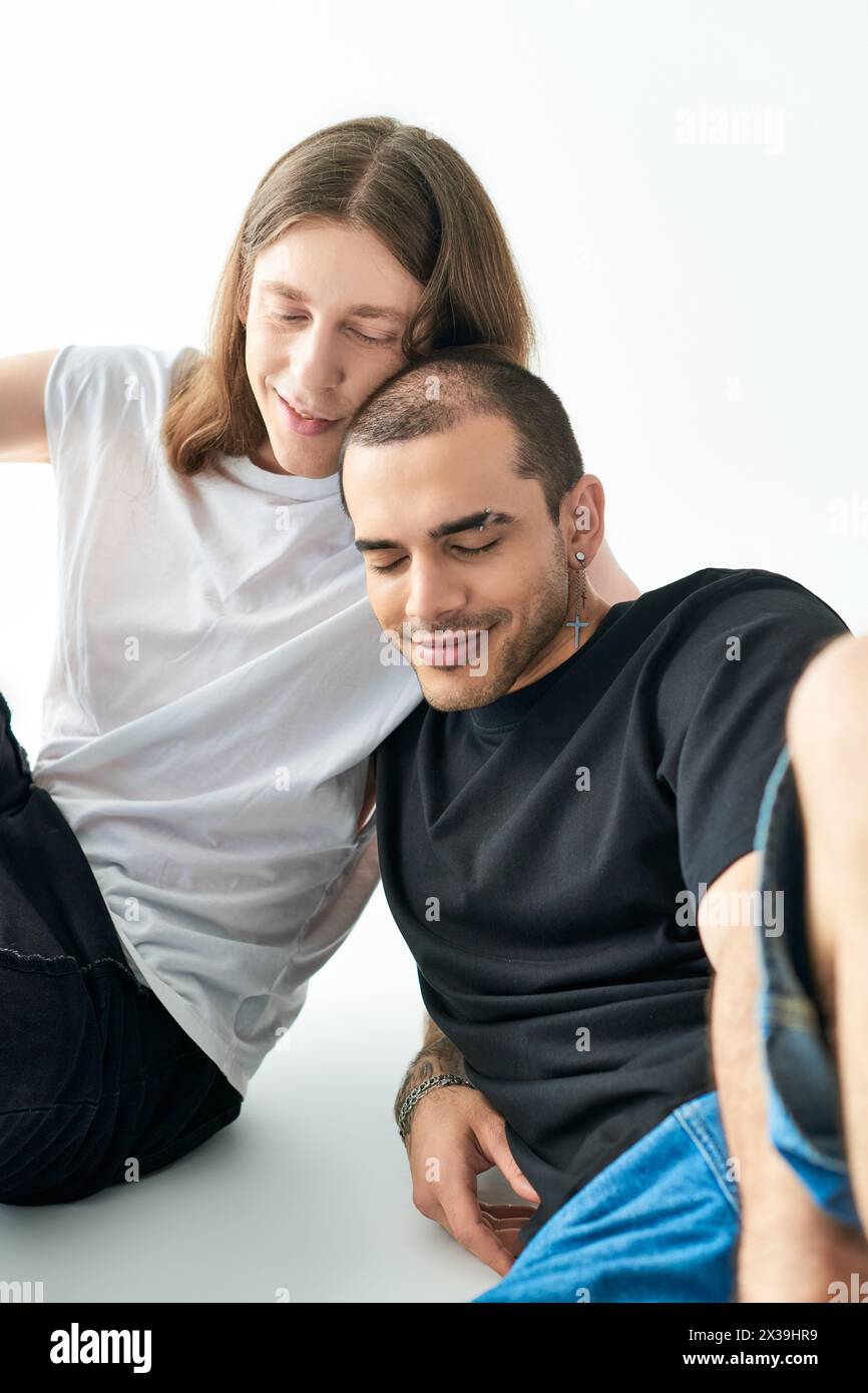 Two men sit together on the floor, sharing a moment of closeness and ...