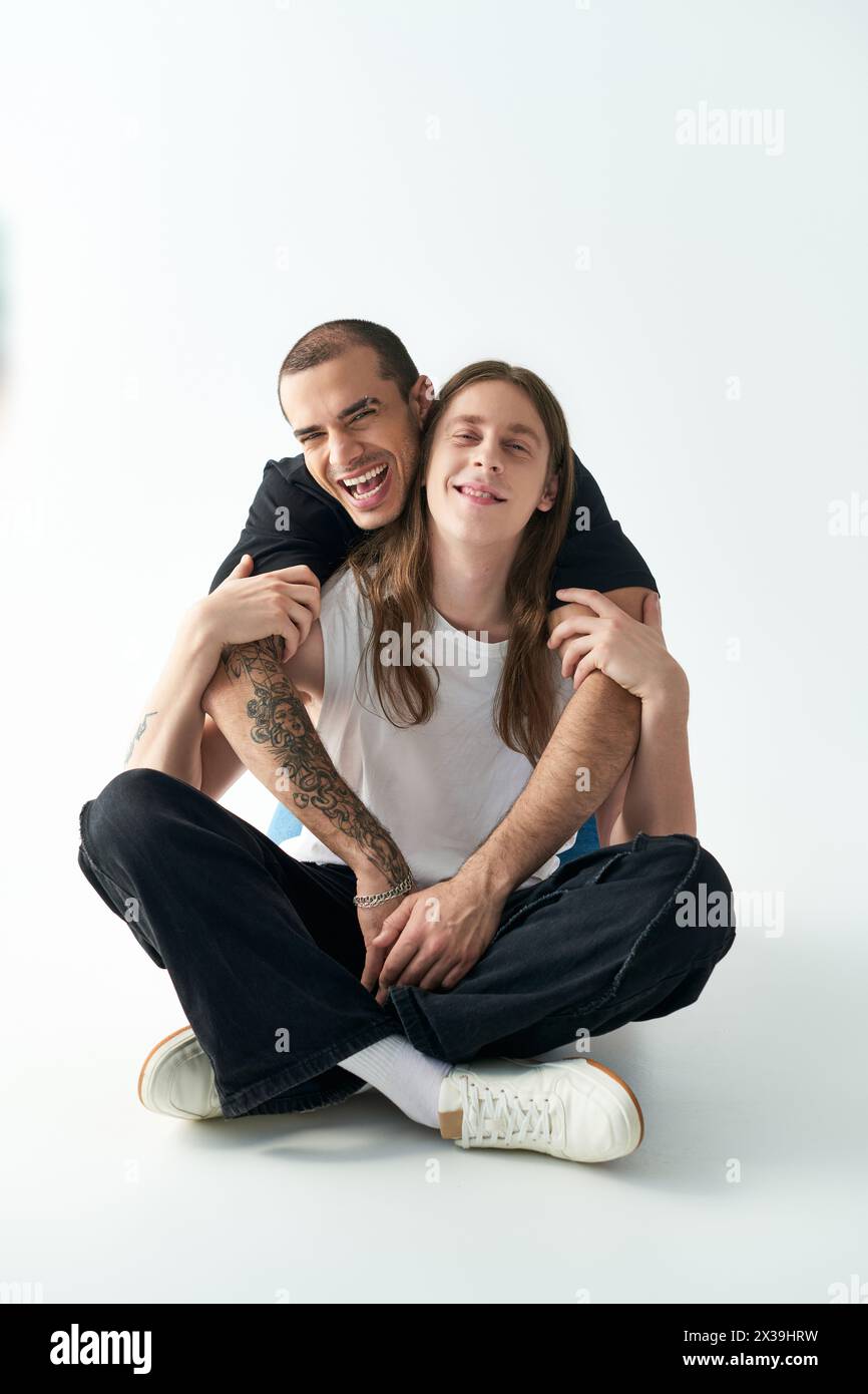 Two men sitting on the ground together Stock Photo - Alamy