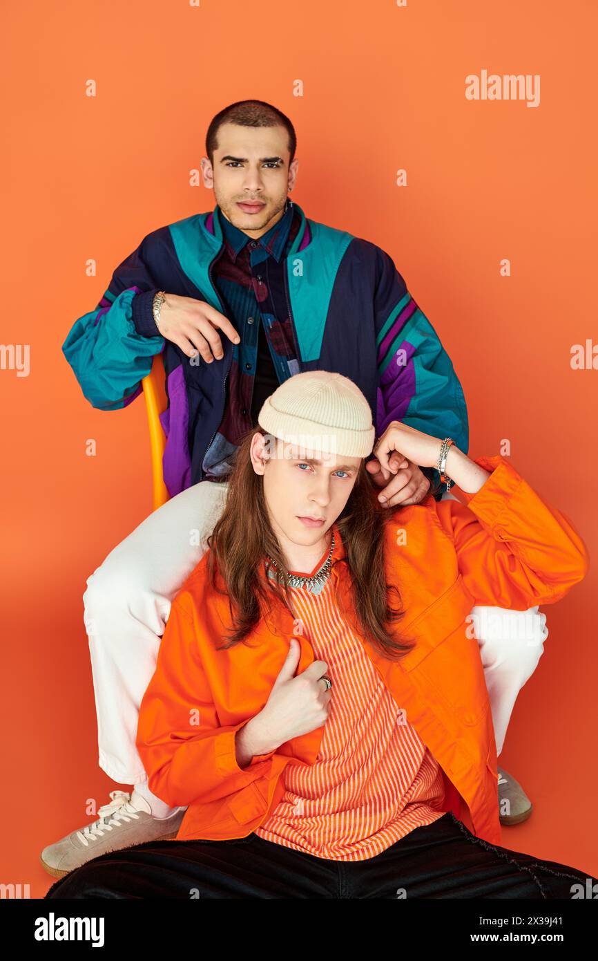 A man perched atop a chair beside his boyfriend Stock Photo - Alamy