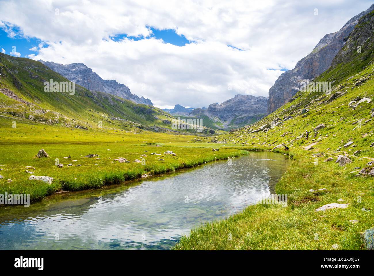 Couple of hikers (unrecognizable people) walking near stream leading to ...