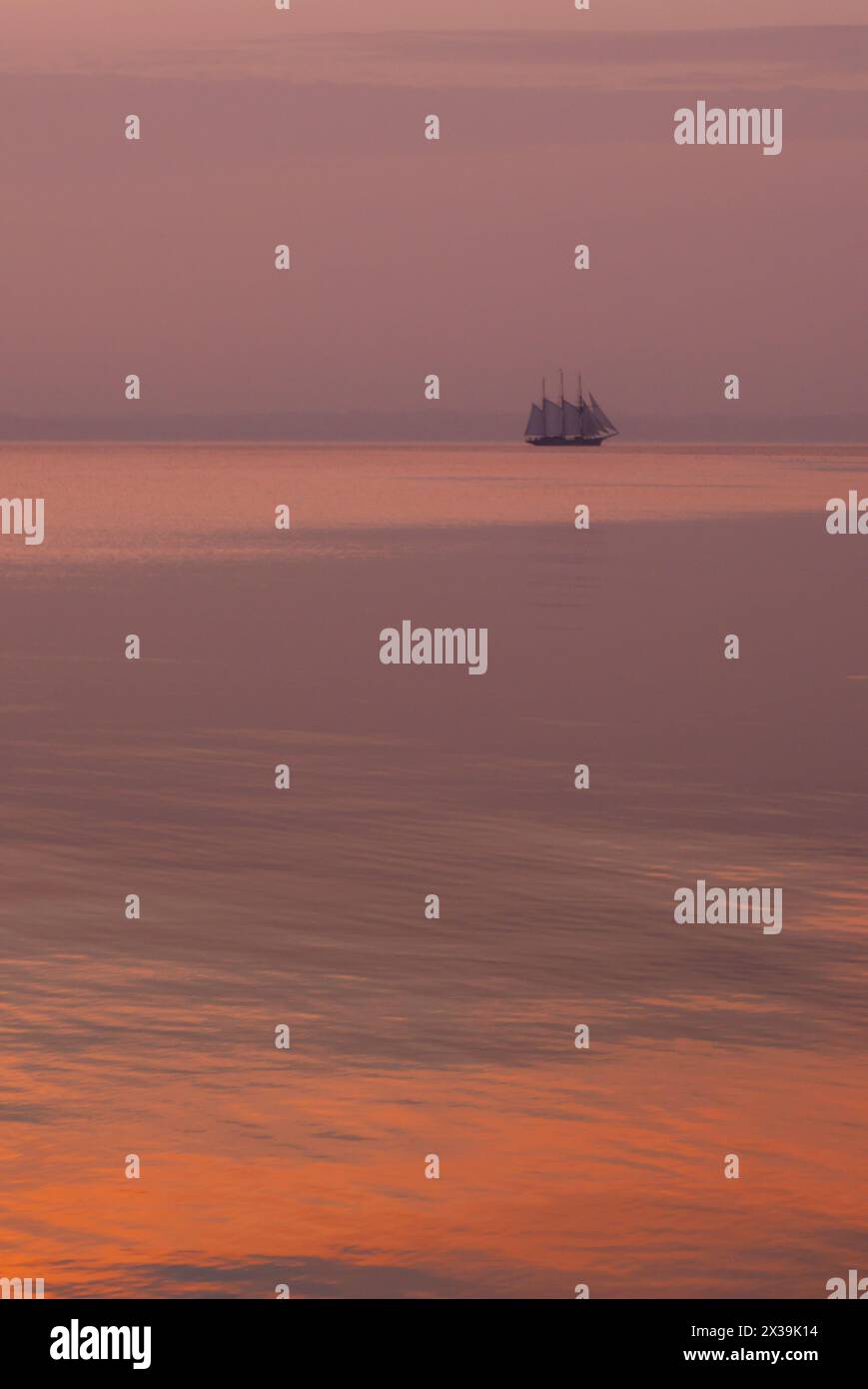 A lonely full rigged ship passing in peach morning light Stock Photo ...