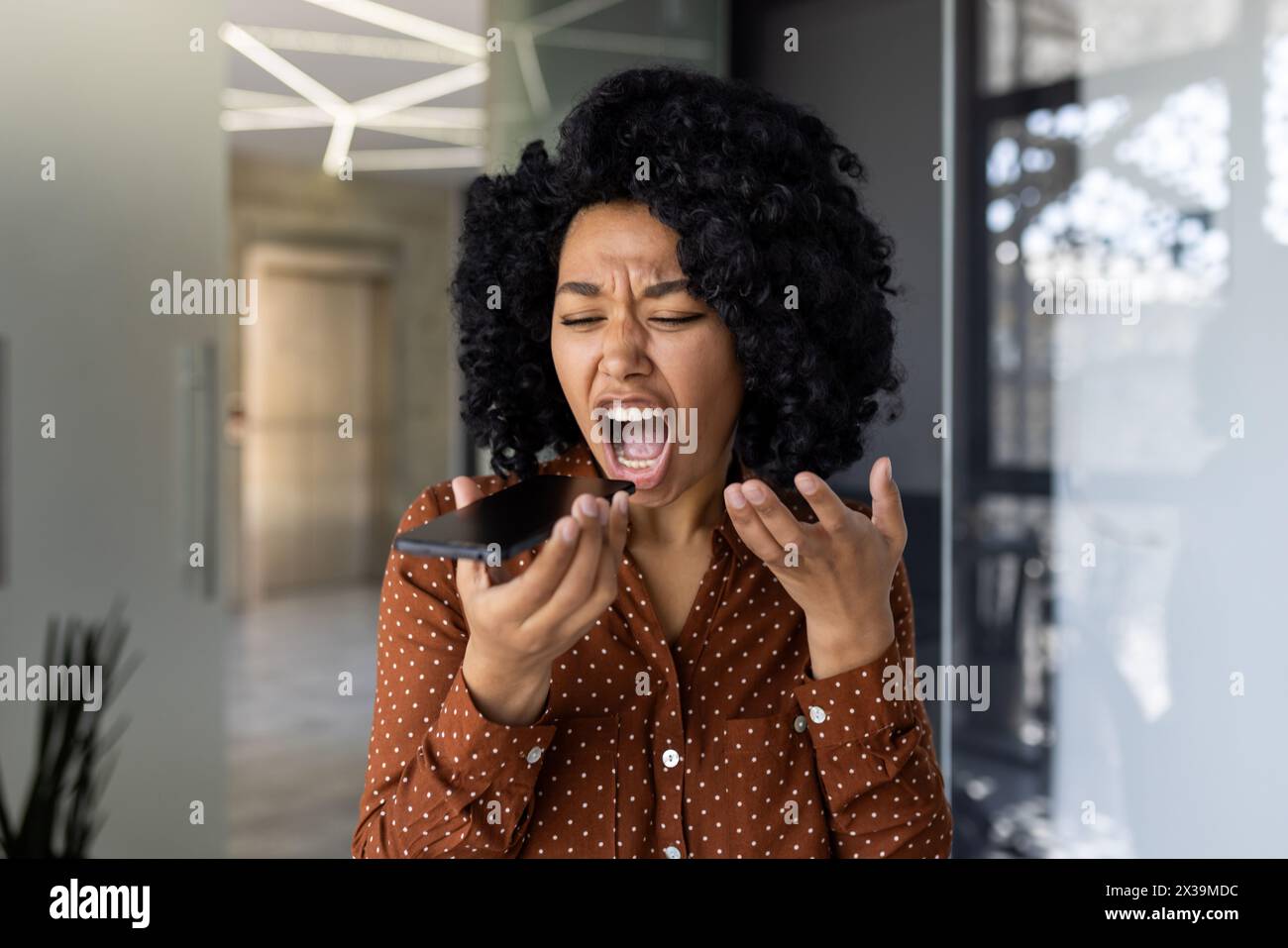 African American woman in a polka dot shirt expressing anger and ...