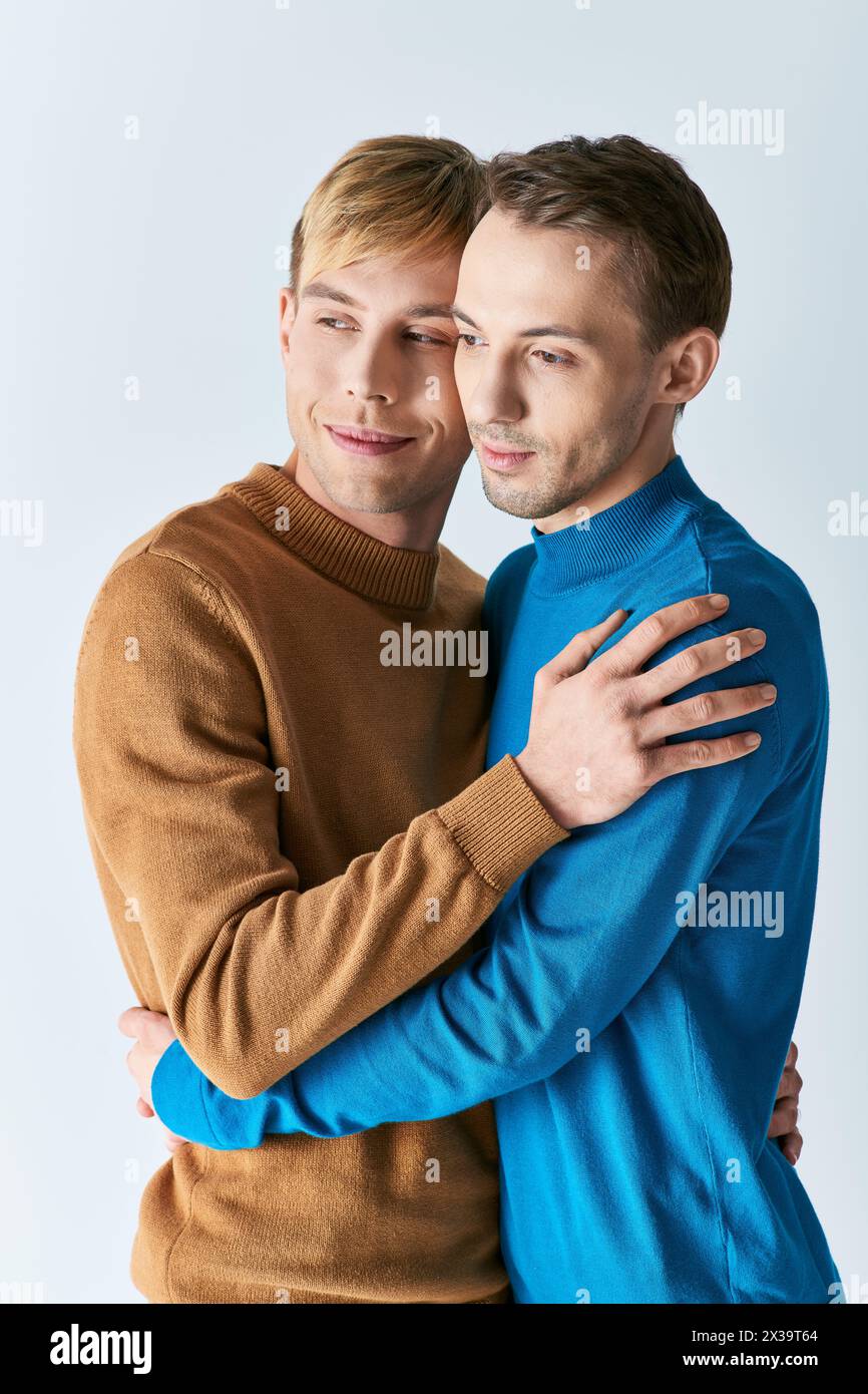 Young men in casual attire hugging in front of a white background Stock ...