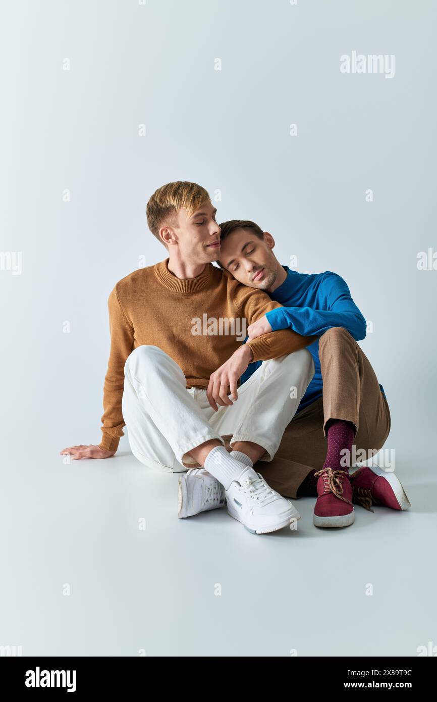 Casual gay couple happily pose on gray backdrop Stock Photo - Alamy