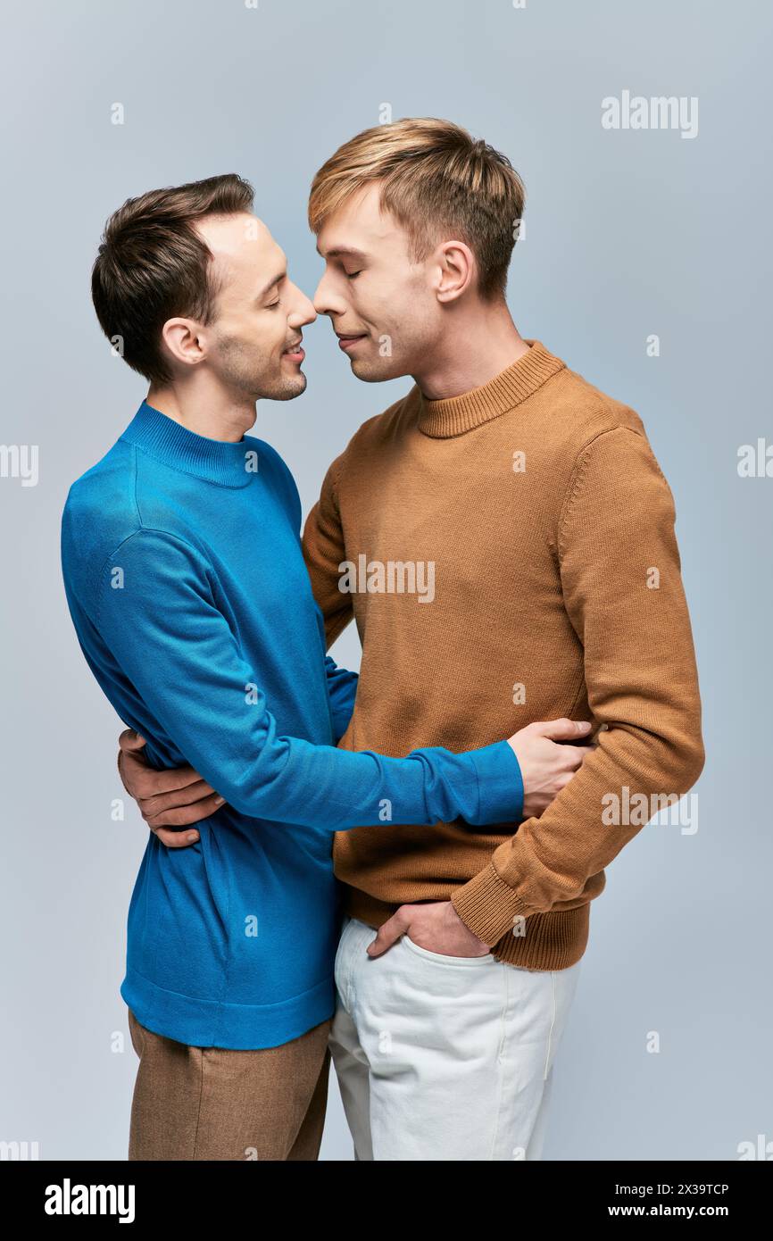 Two men in casual attire standing with arms around each other, showing ...