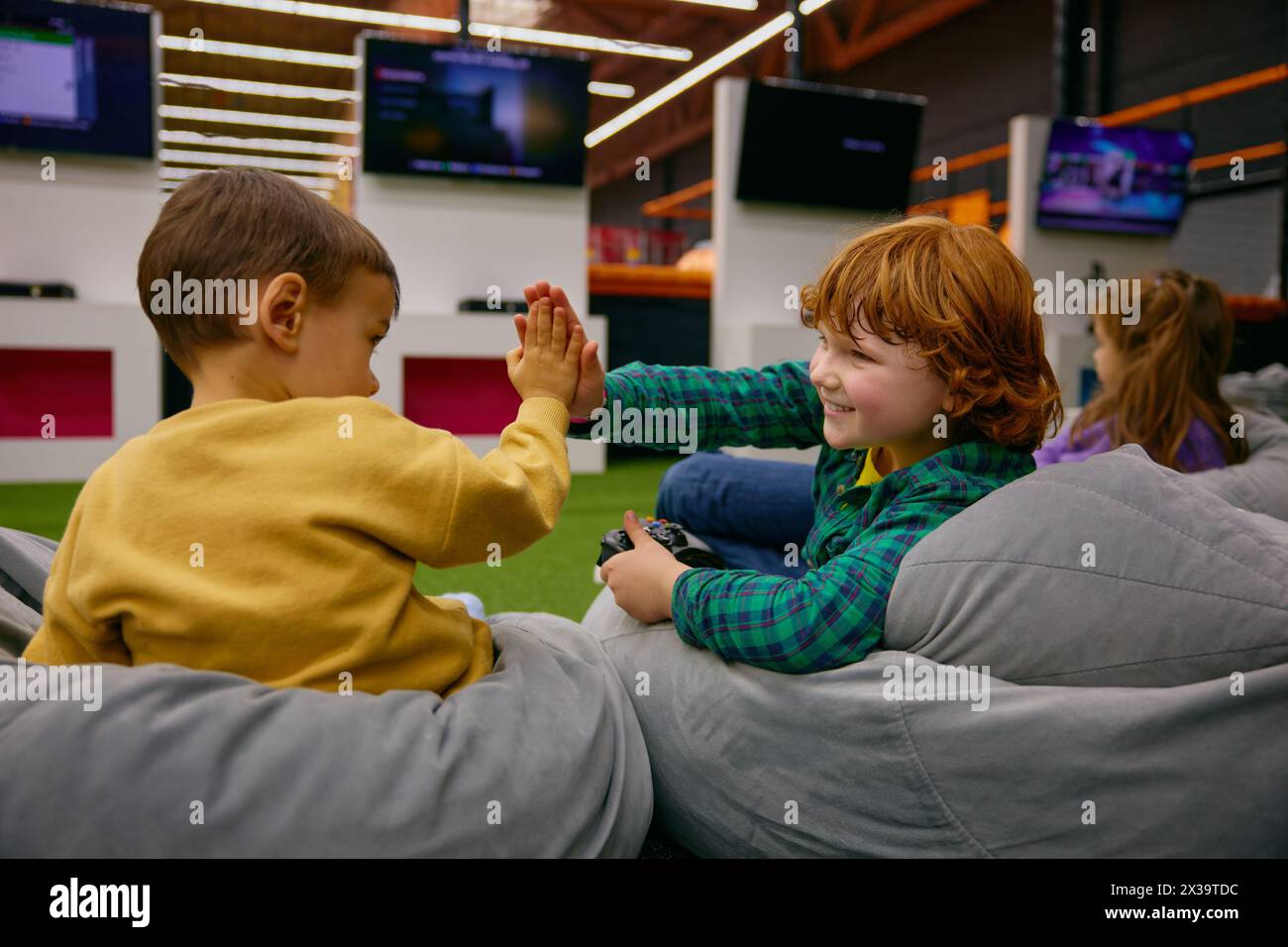 Happy boys siblings wining competition while playing video game in kids ...