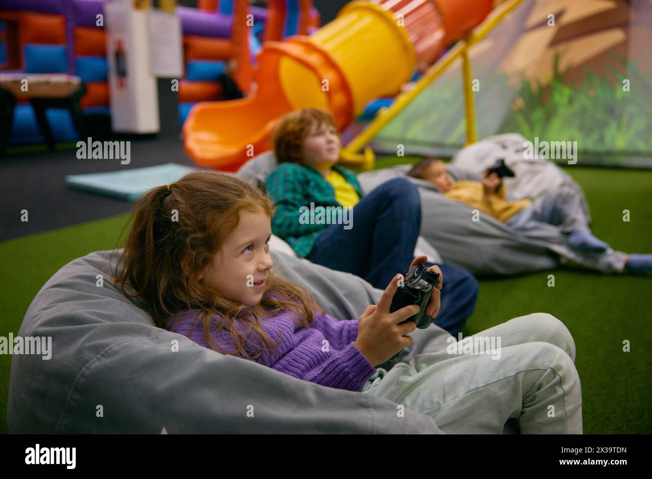 Little children playing video game in entertainment center Stock Photo ...
