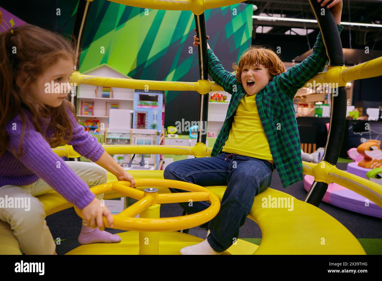 Happy excited children playing on indoor carousel at play center Stock ...