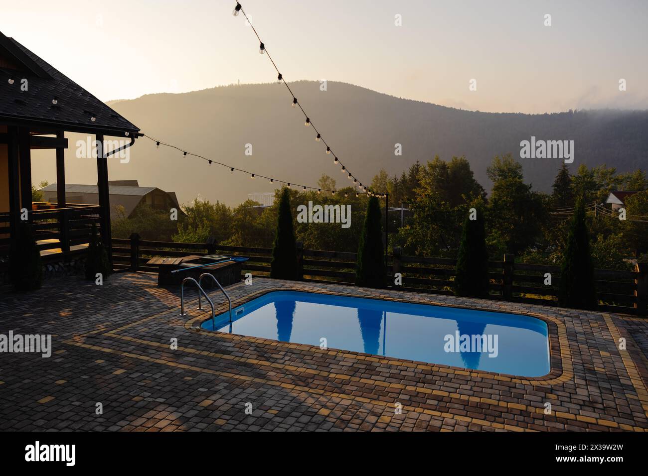 A clear, rectangular swimming pool is positioned in the center of a ...