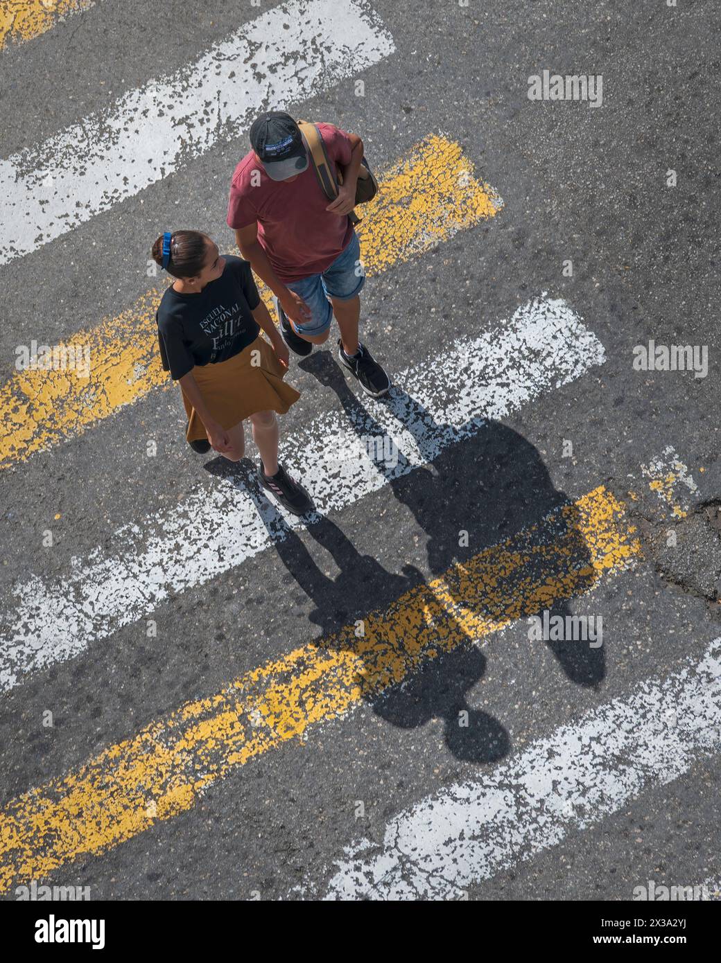 View from a rooftop, looking down on two people walking across a ...