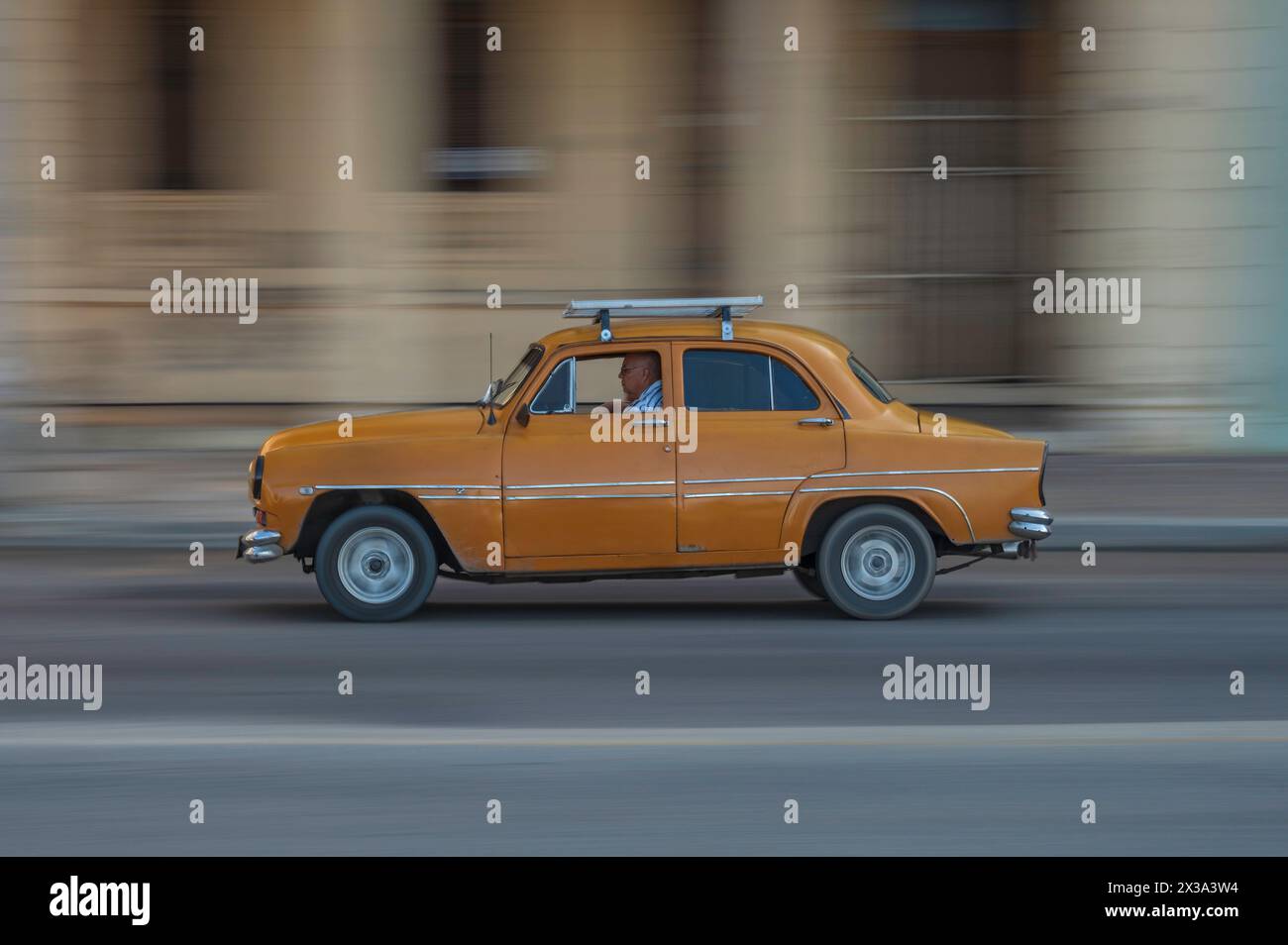 Classic car being driven along the sea front on the Malecon in front of ...