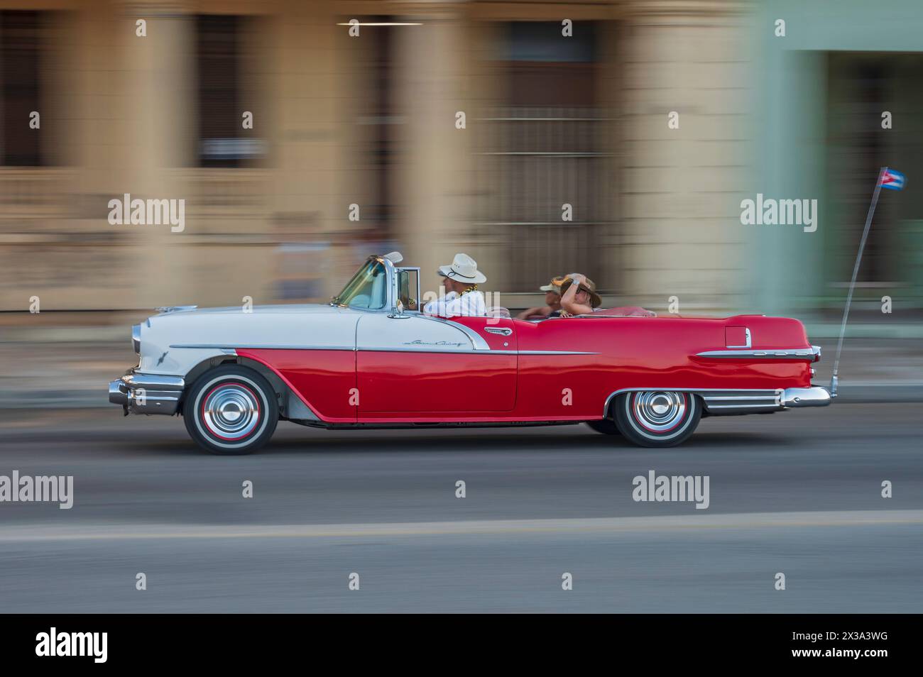 Classic car being driven along the sea front on the Malecon in front of ...