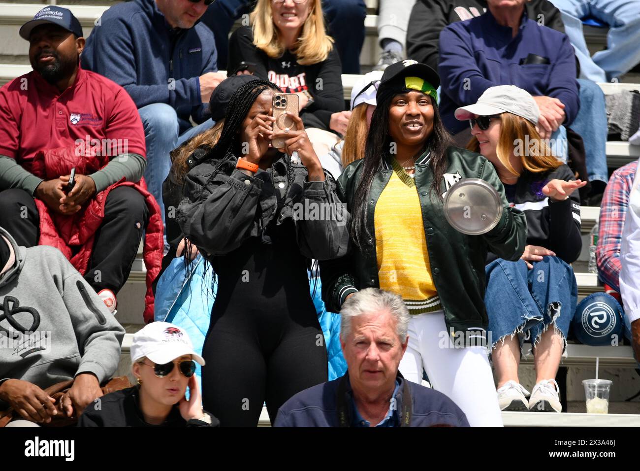 Spectators watch as athletes compete in the running of the first day of ...