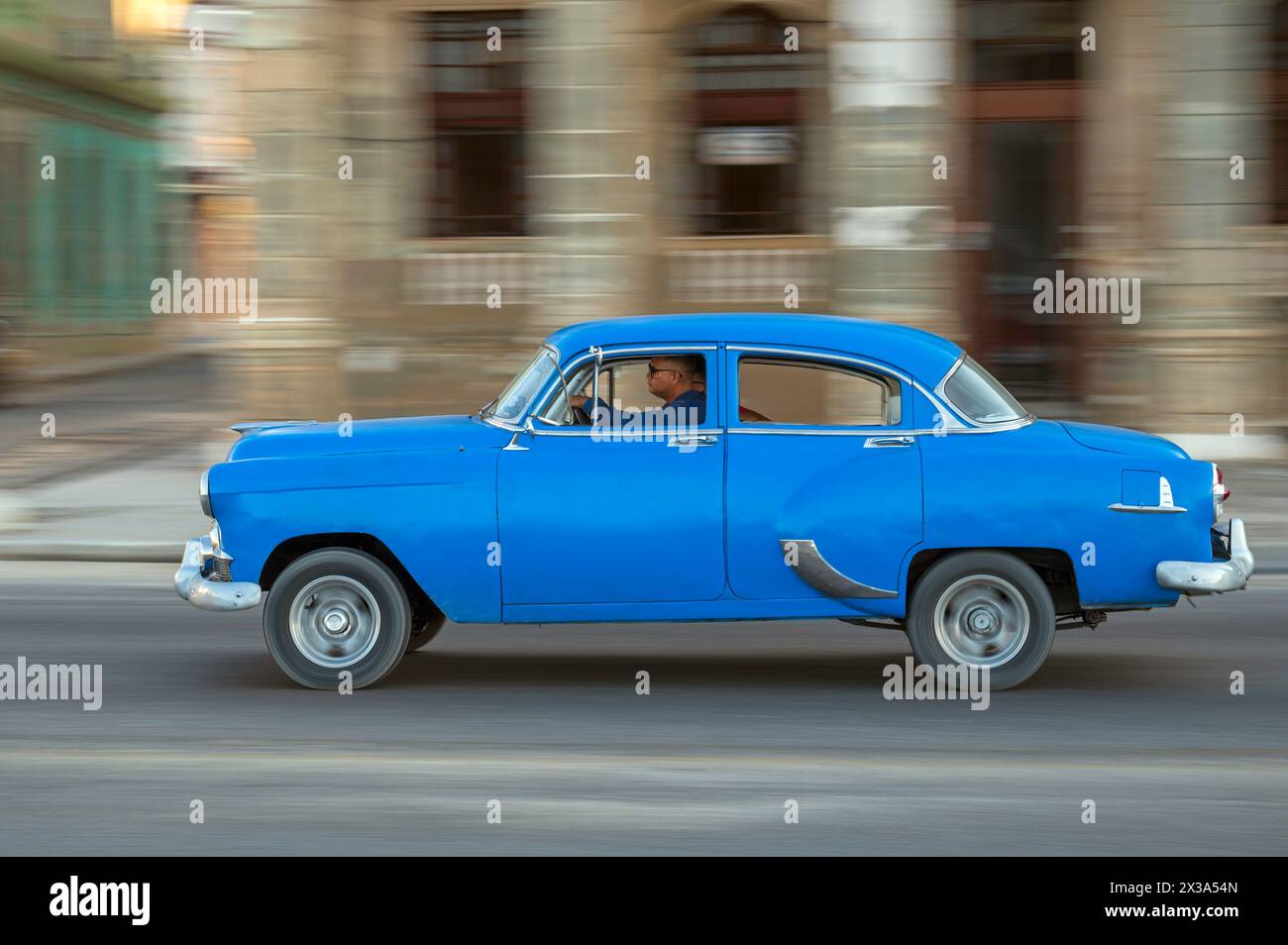 Classic car being driven along the sea front on the Malecon in front of ...