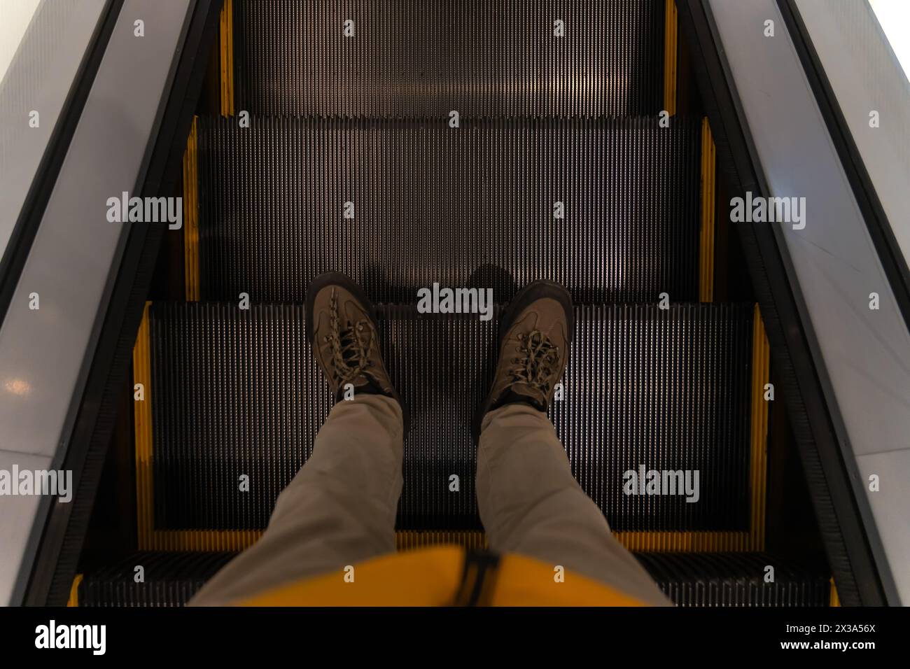 Men's feet in sports shoes on the escalator, top view Stock Photo - Alamy