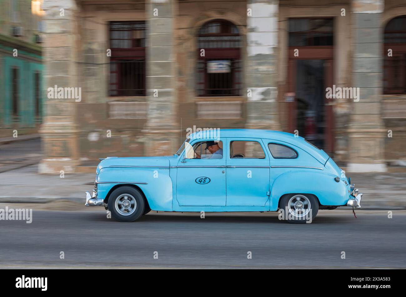Classic car being driven along the sea front on the Malecon in front of ...