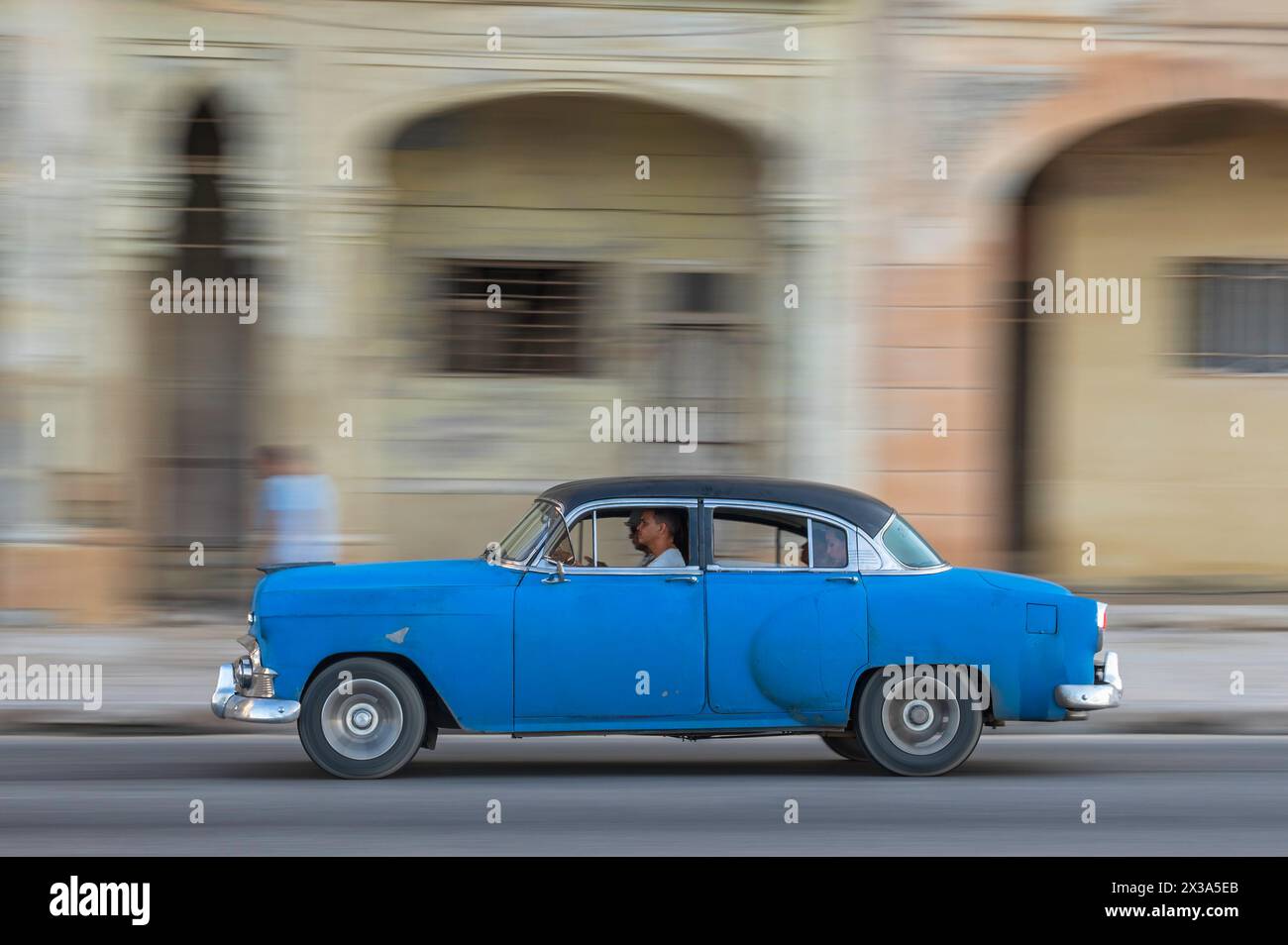 Classic car being driven along the sea front on the Malecon in front of ...
