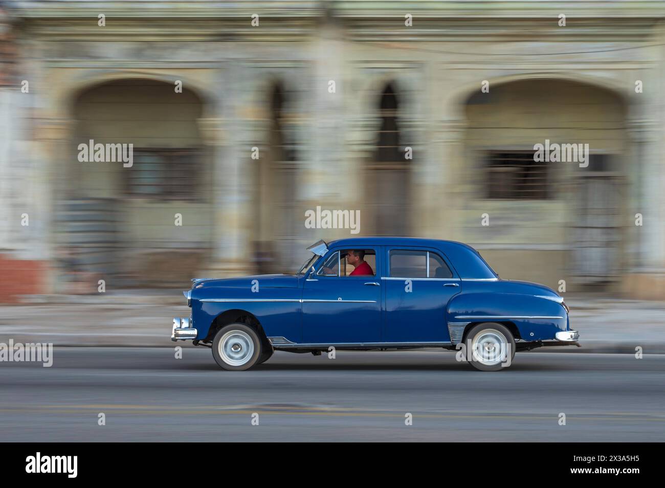 Classic car being driven along the sea front on the Malecon in front of ...