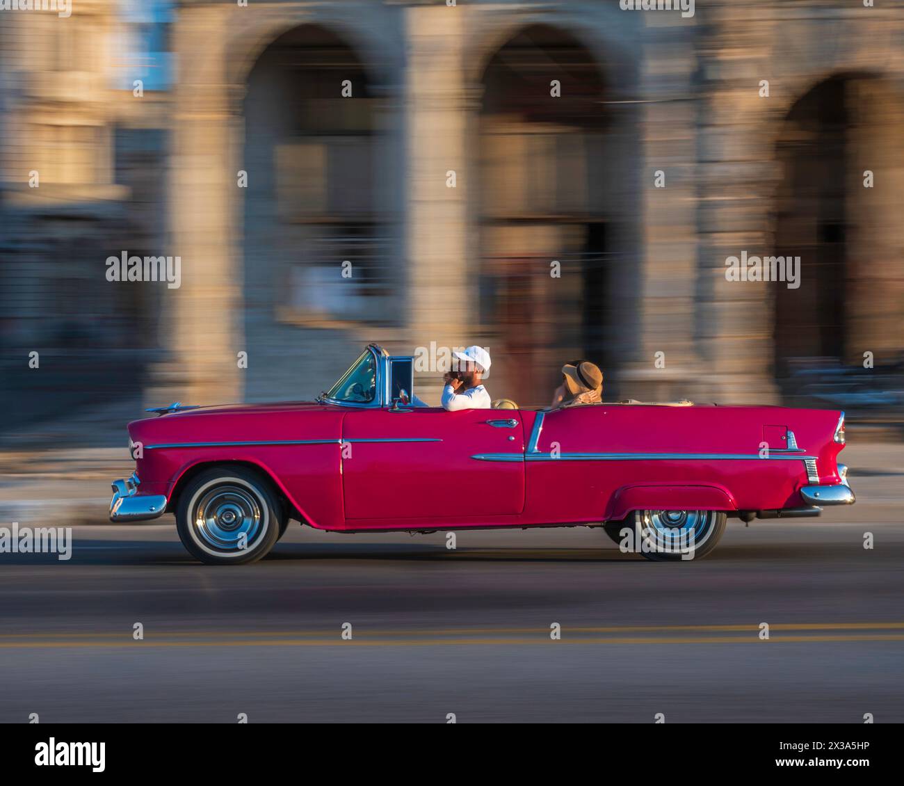 Classic car being driven along the sea front on the Malecon in front of ...