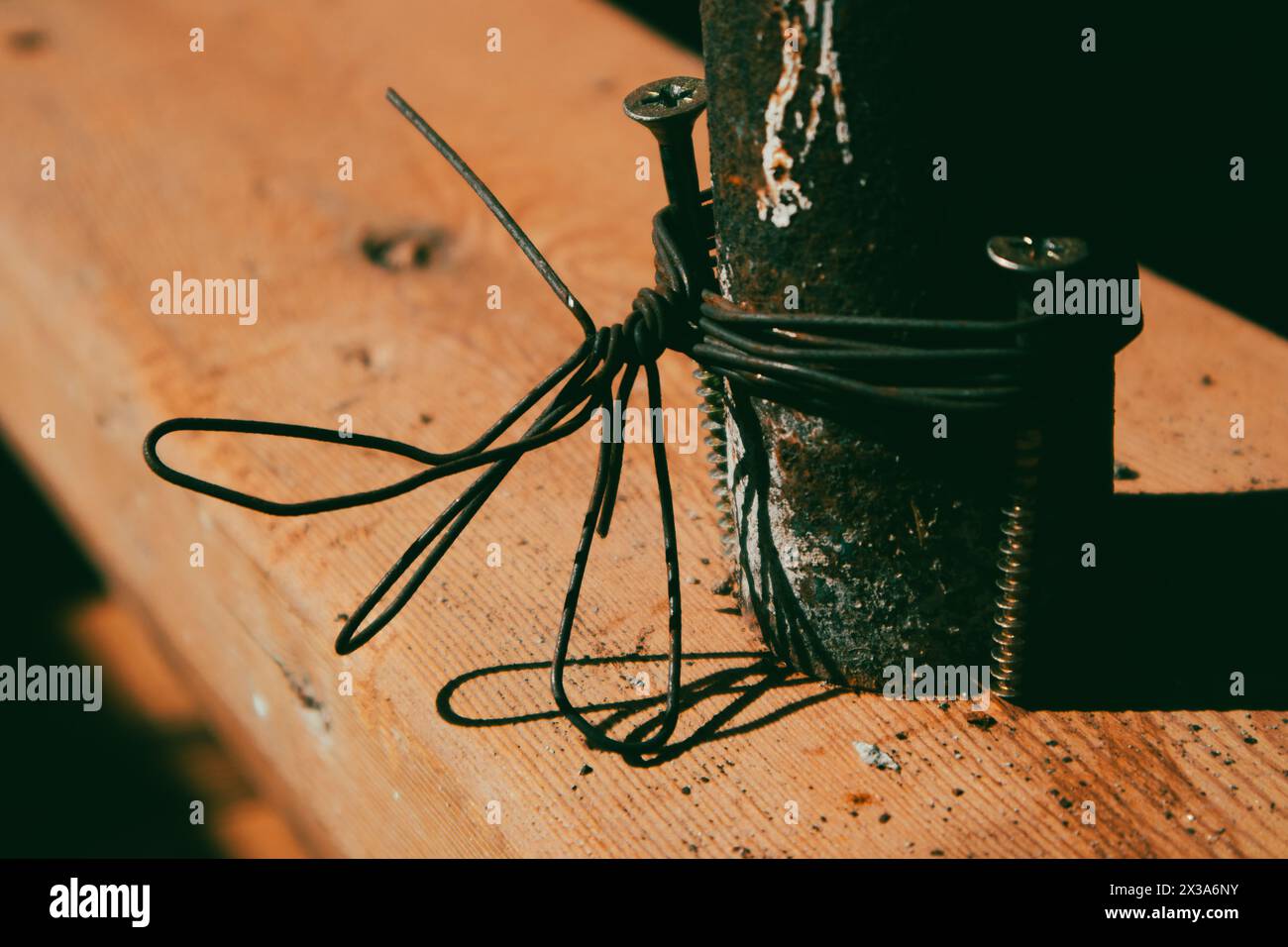 Nail and metal wire tied to a grunge old pipe vintage background brown ...