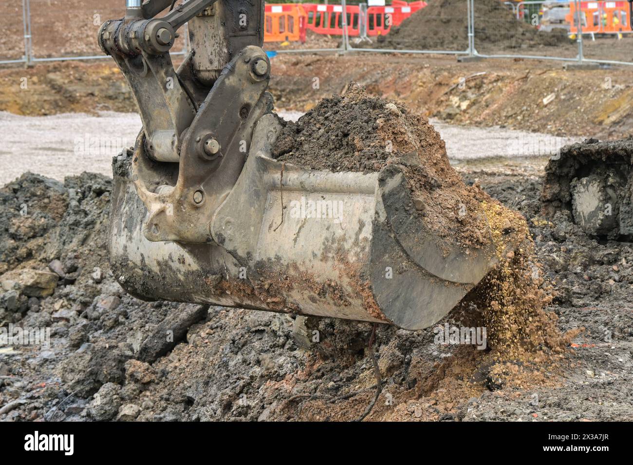 Bucket of an excavator scooping up soil and rubble on a construction ...