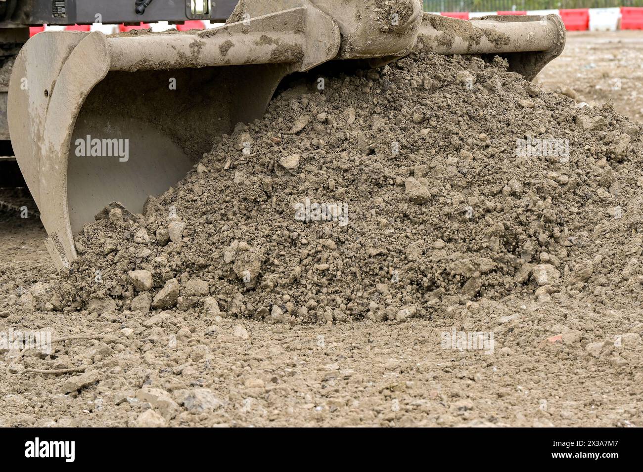 Bucket of an excavator scooping up soil and rubble on a construction ...