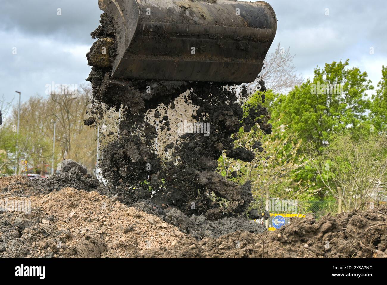 Excavator tipping soil and rubble on a construction site. No people ...