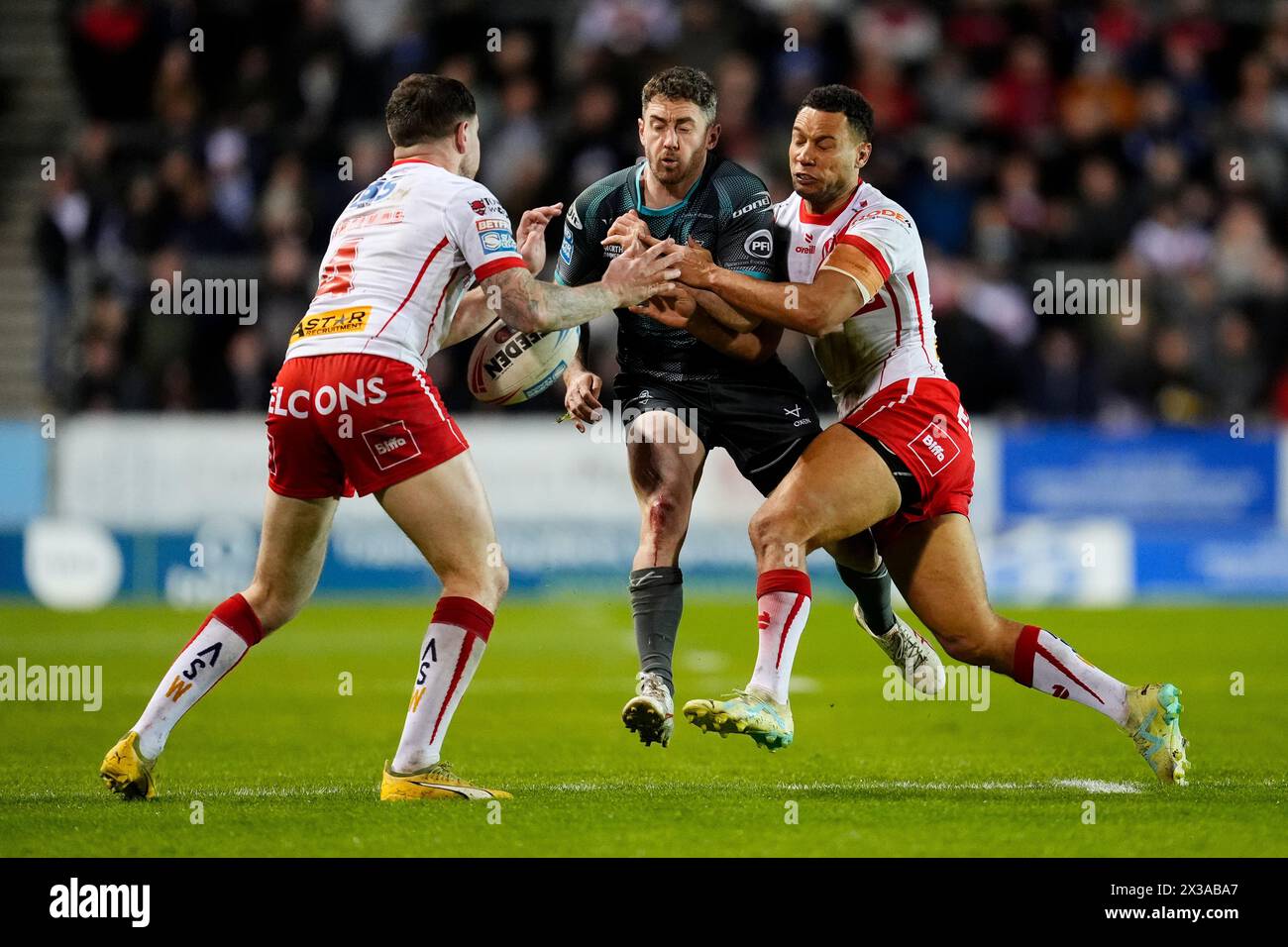 Huddersfield Giants' Adam Clune (centre) is tackled by St Helens' Moses ...
