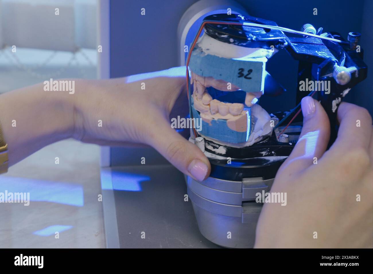 The dental technician places the denture into the scanner to reproduce ...