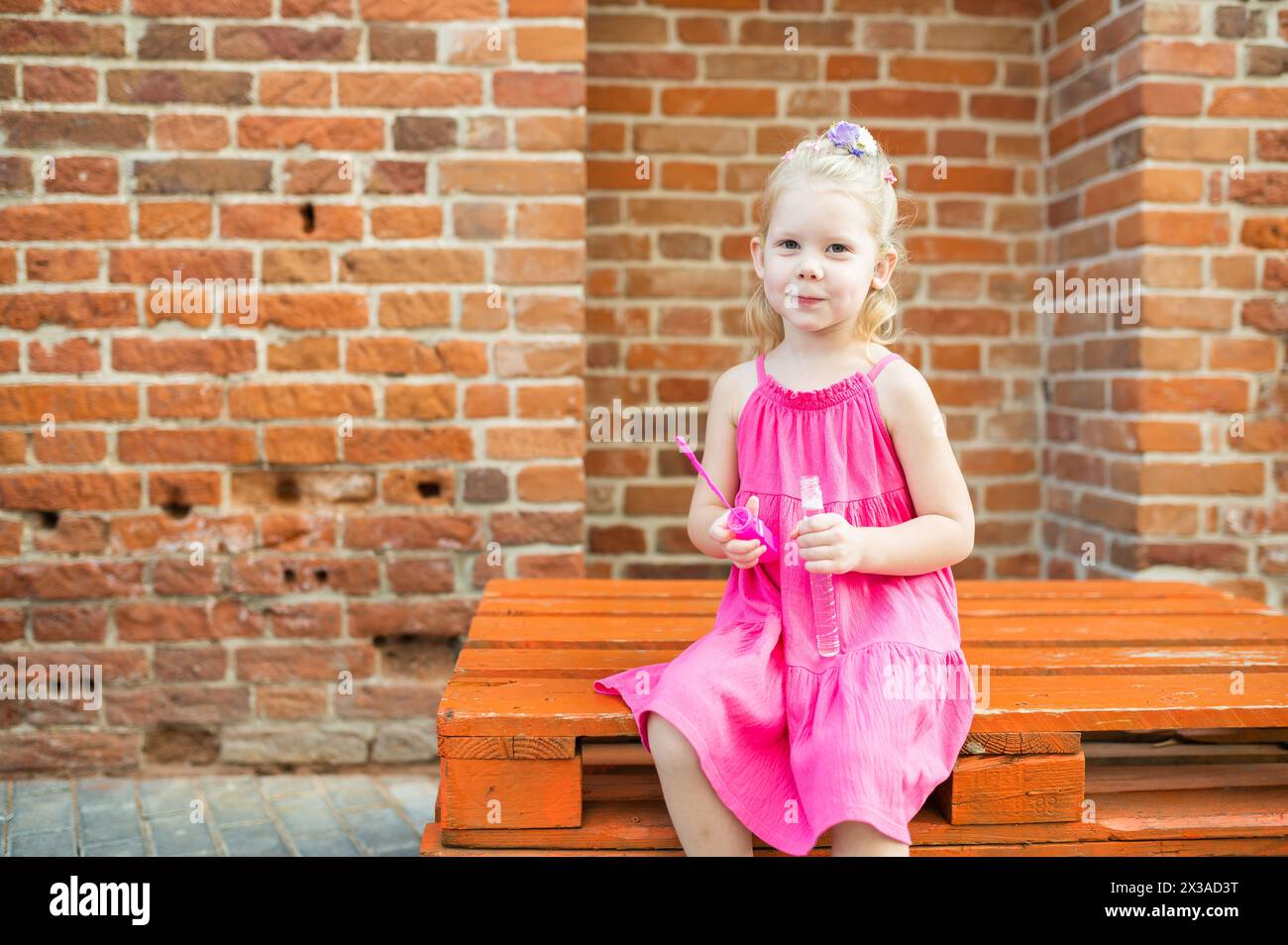 Child girl walks and have fun outdoor with cochlear implant on the head ...