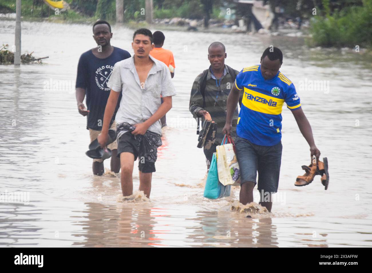 Dar Es Salaam, Tanzania. 25th Apr, 2024. People walk through a flooded ...