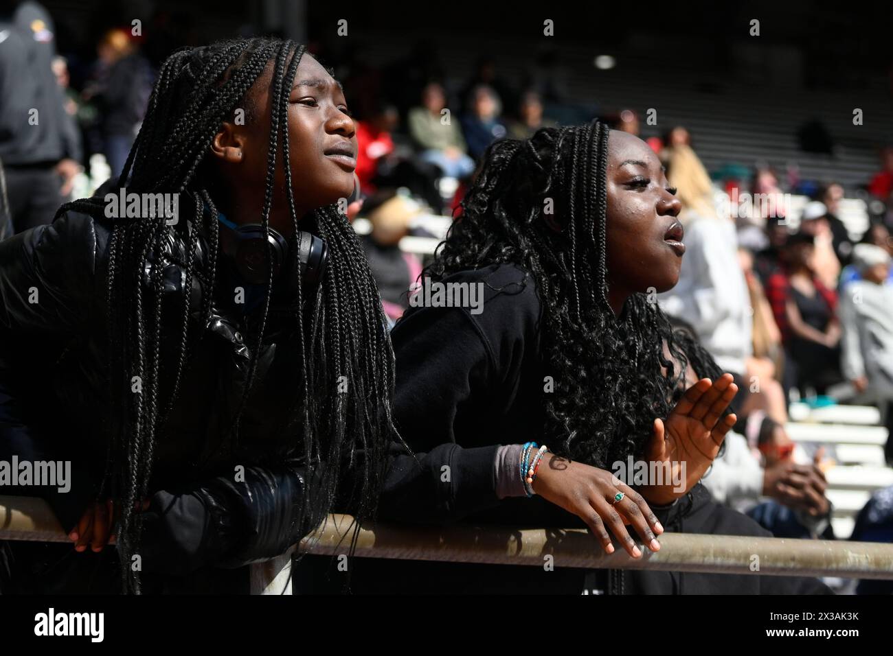 Spectators watch athletes compete in the 4x400m event of the first day ...