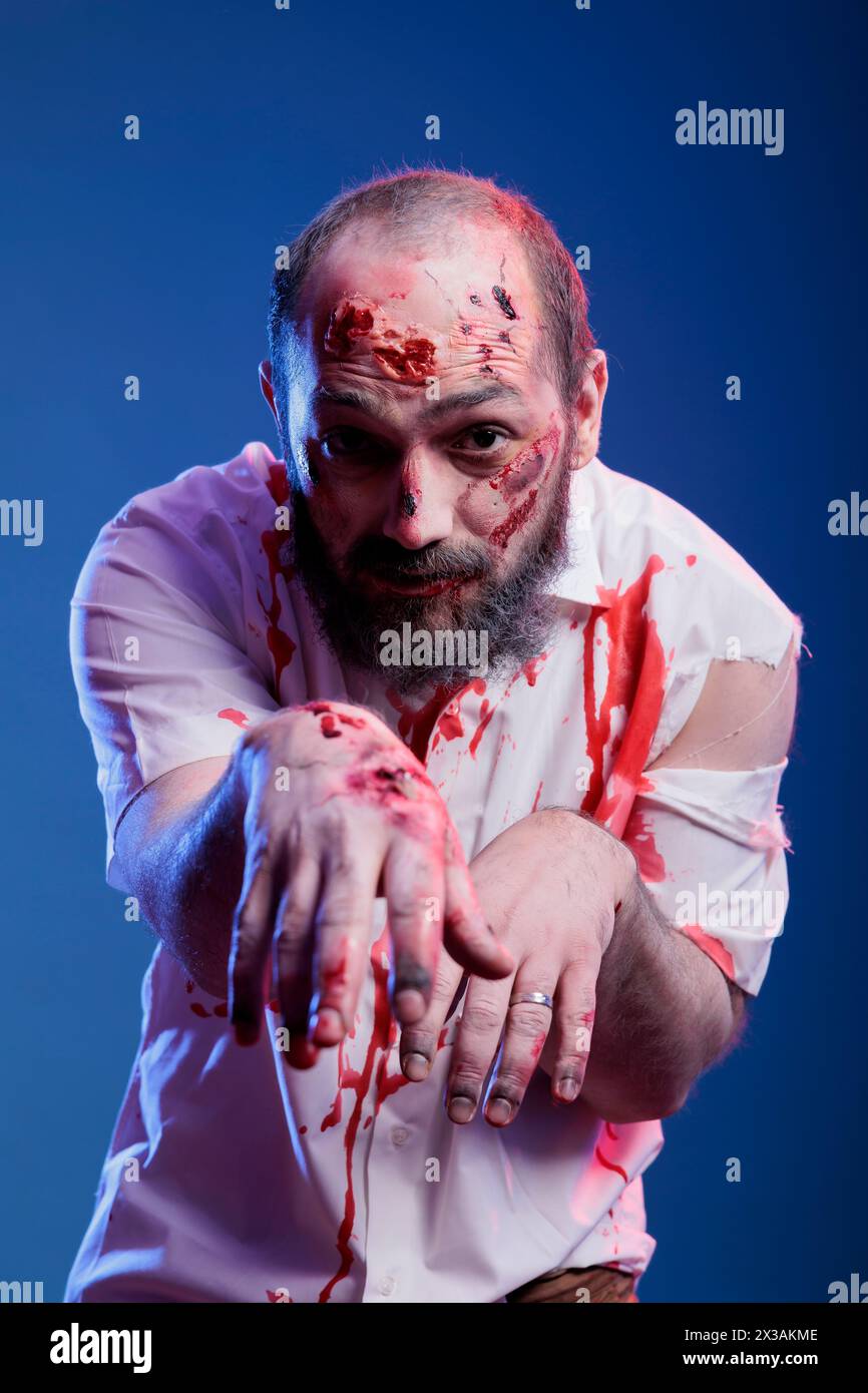 Portrait of man dressed as terrifying creepy zombie covered in blood ...