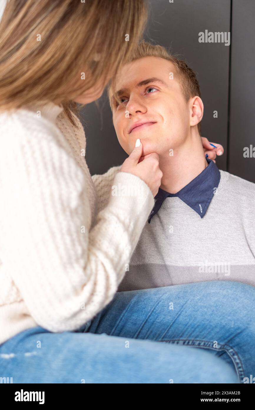 A woman gently touches a mans face, their eye contact reflecting a deep ...