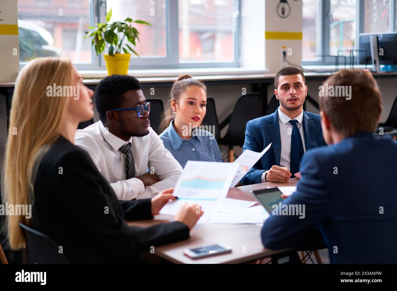 Multiethnic group of professionals engaged in a business meeting ...