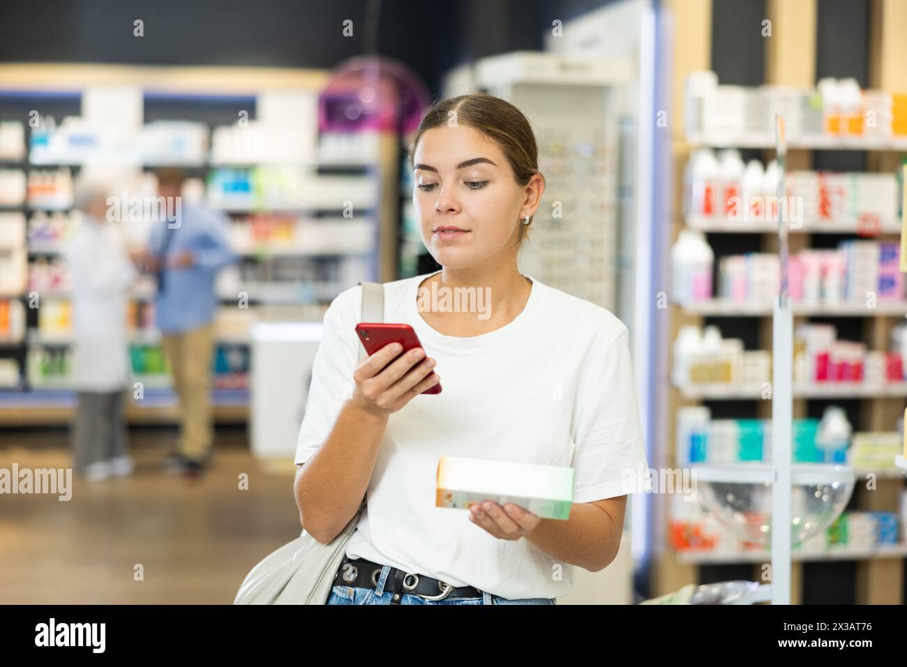 In pharmacy girl visitor scan QR Code and reads composition of cream ...