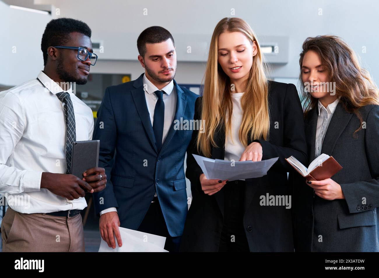 Multiethnic corporate team collaborates in office setting, reviewing ...