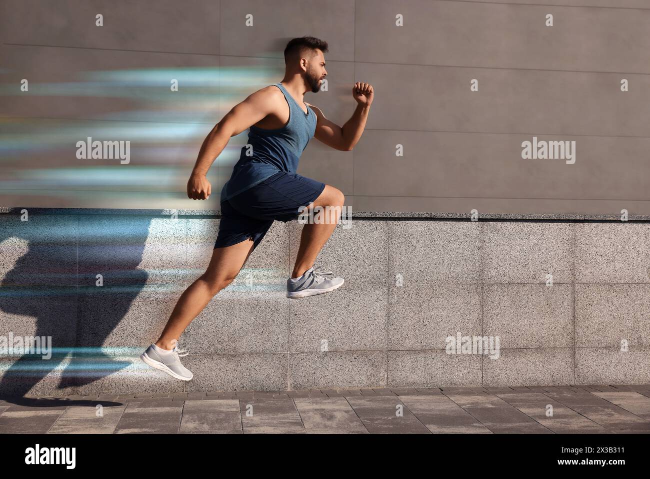 Sporty young man running on street. Light trails showing his speed ...