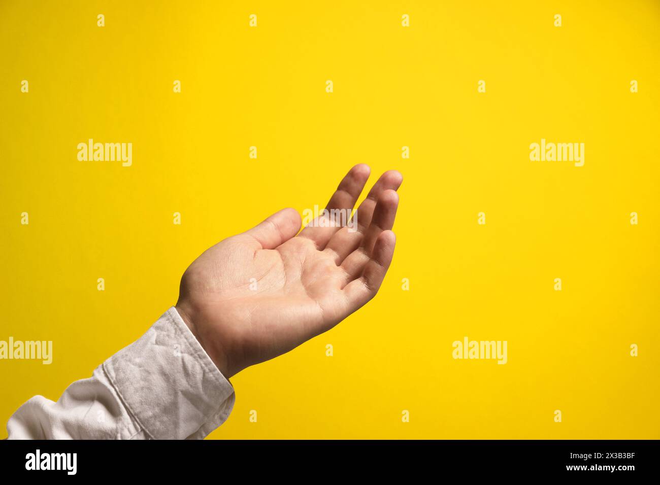 Man holding something in hand on yellow background, closeup Stock Photo ...