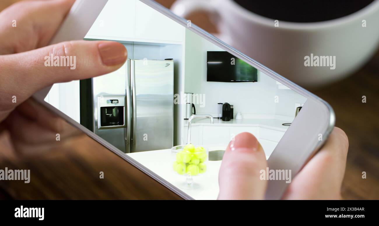 Image of person using smartphone with house kitchen interiors displayed ...