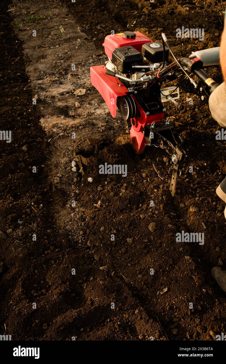 a tillerblock plows the land in the garden. A tillerblock for plowing ...
