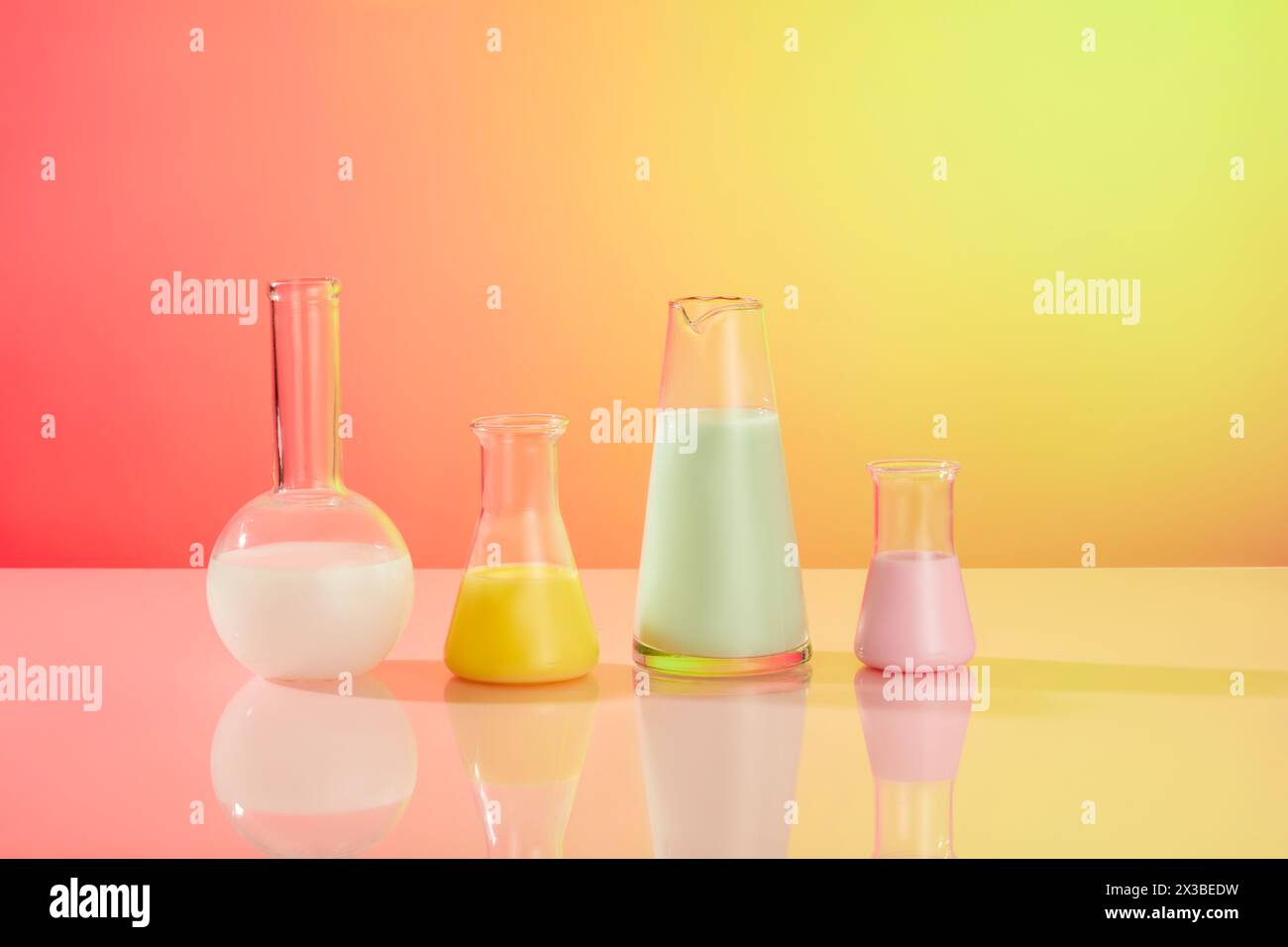 Four laboratory flasks filled with pastel liquid are decorated over ...